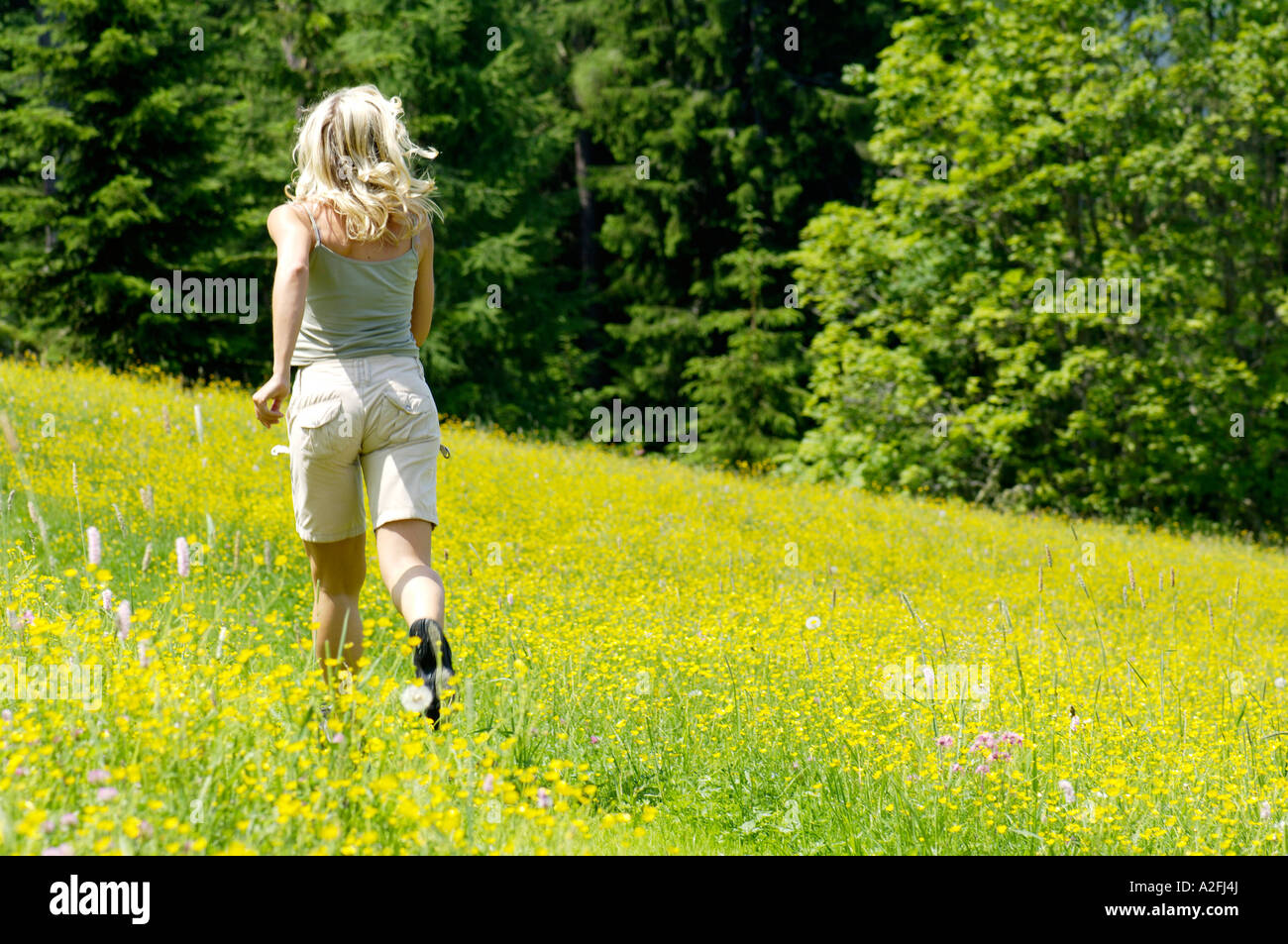 Young woman walking in field Stock Photo - Alamy