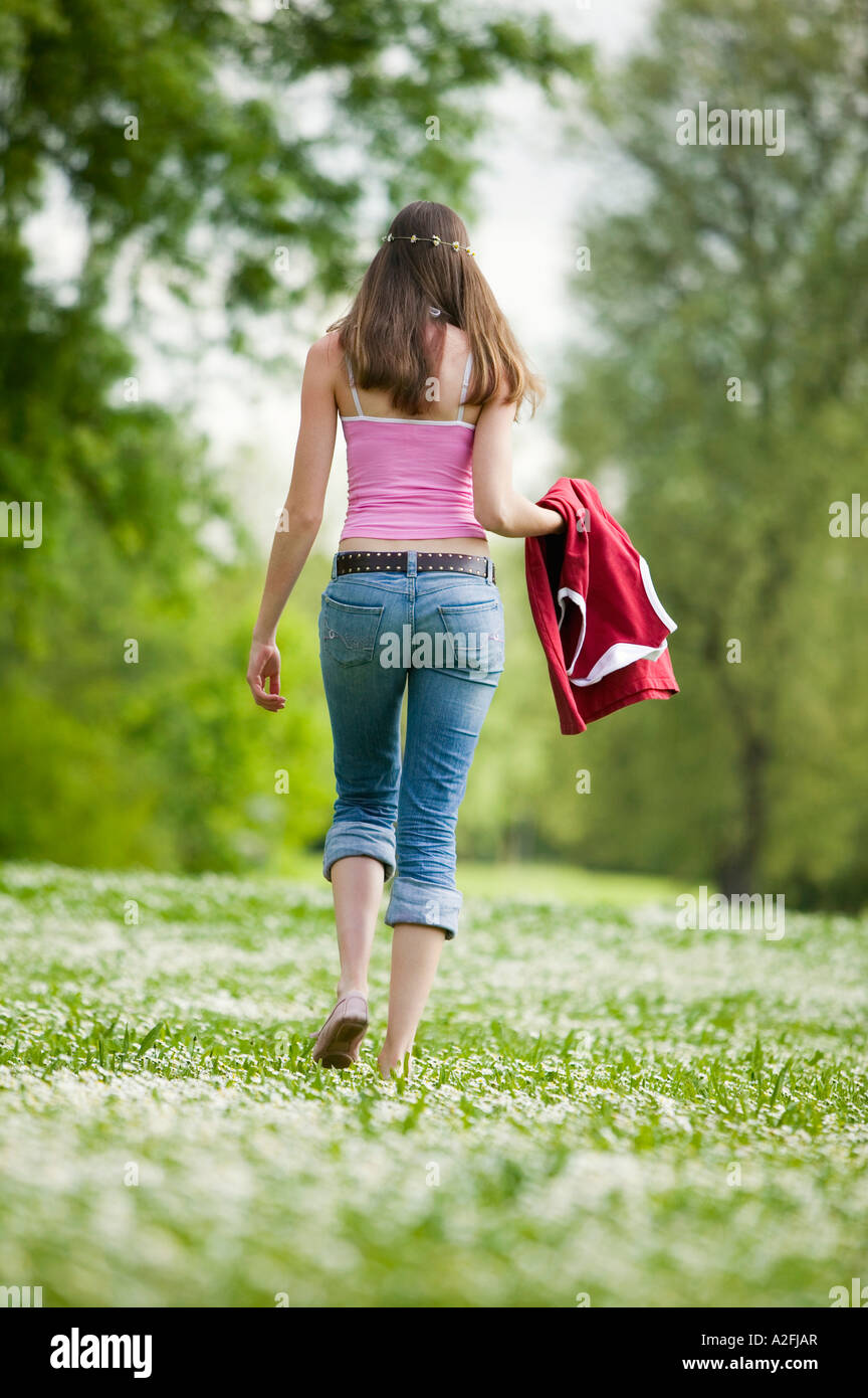 Young woman walking in meadow, rear view Stock Photo - Alamy
