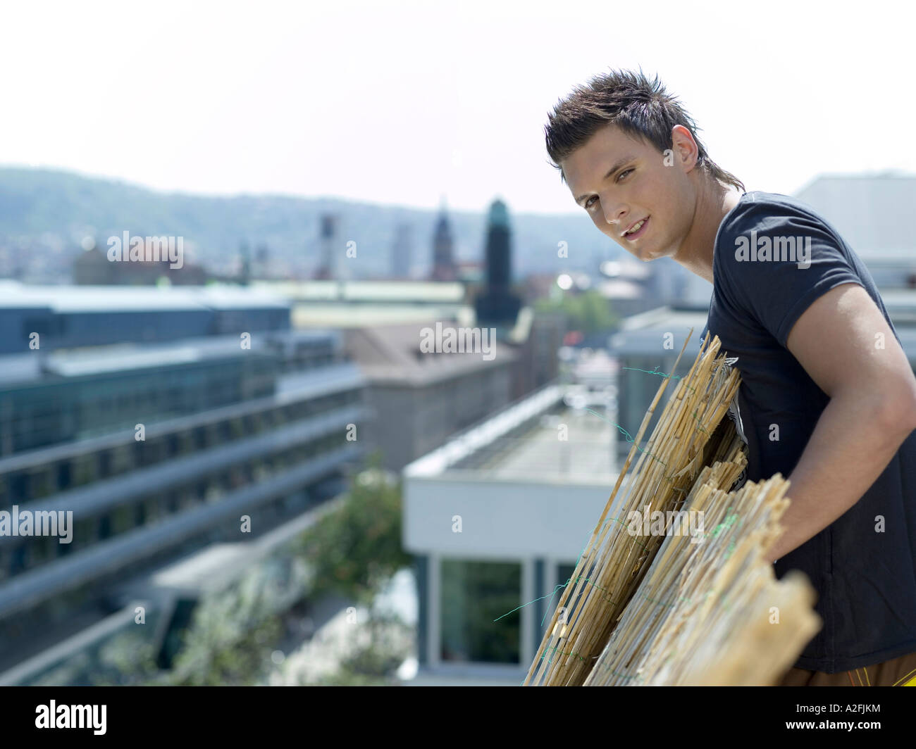 Young man standing on roof Stock Photo - Alamy