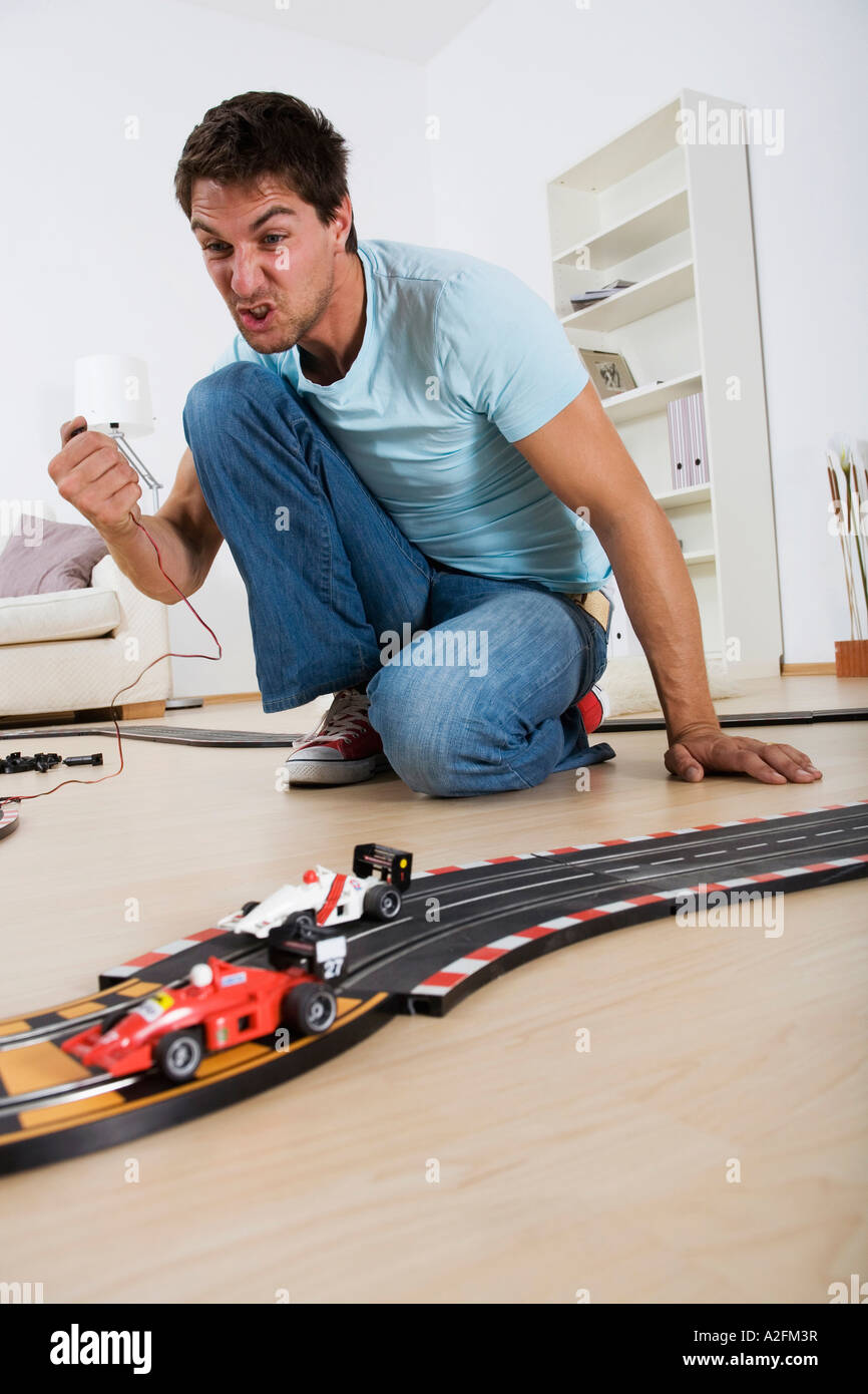 Man playing with toy racetrack Stock Photo - Alamy