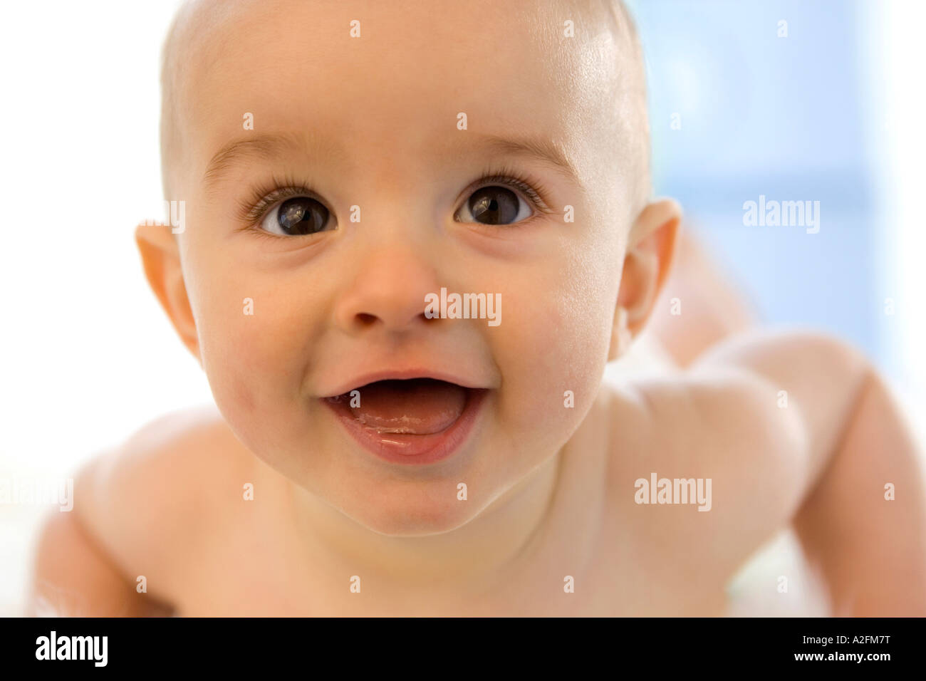 Baby boy ( 6-12 months) lying on belly, smiling Stock Photo - Alamy
