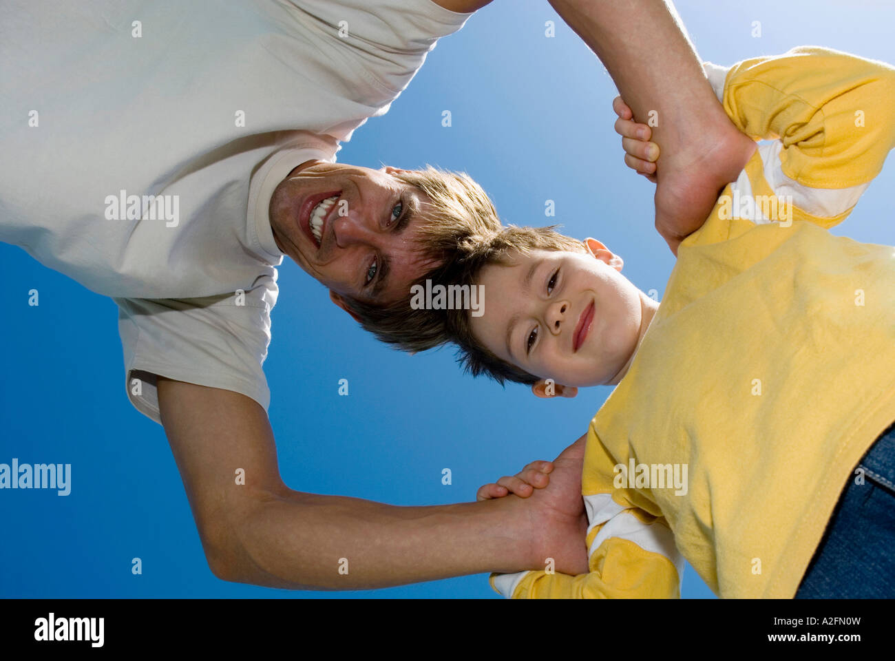 Father and son (4-7) head to head, view from below Stock Photo - Alamy