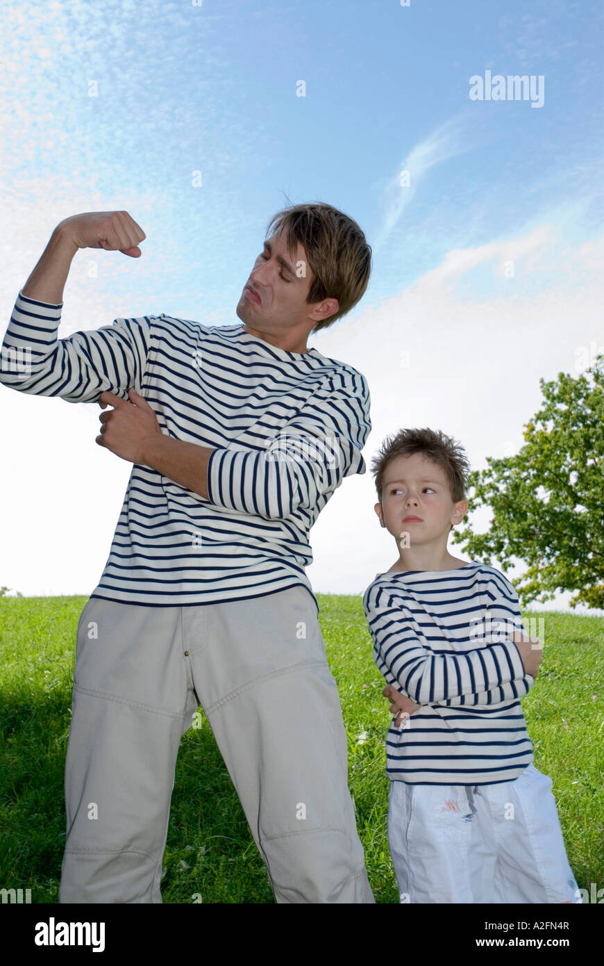 Father and son (4-7) flexing muscles, standing in park Stock Photo - Alamy