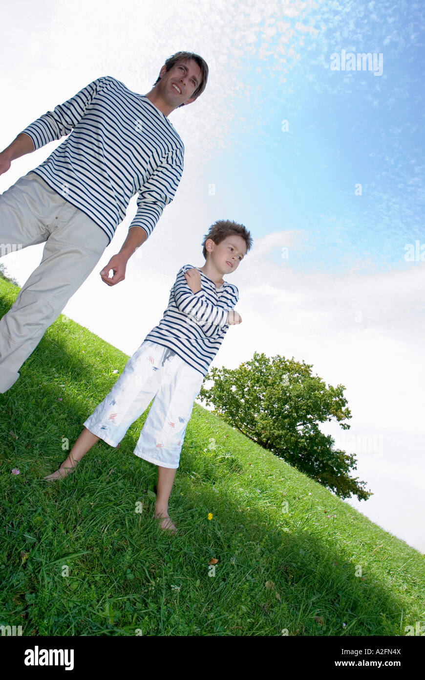 Father and son (4-7) standing in park, low angle view Stock Photo - Alamy