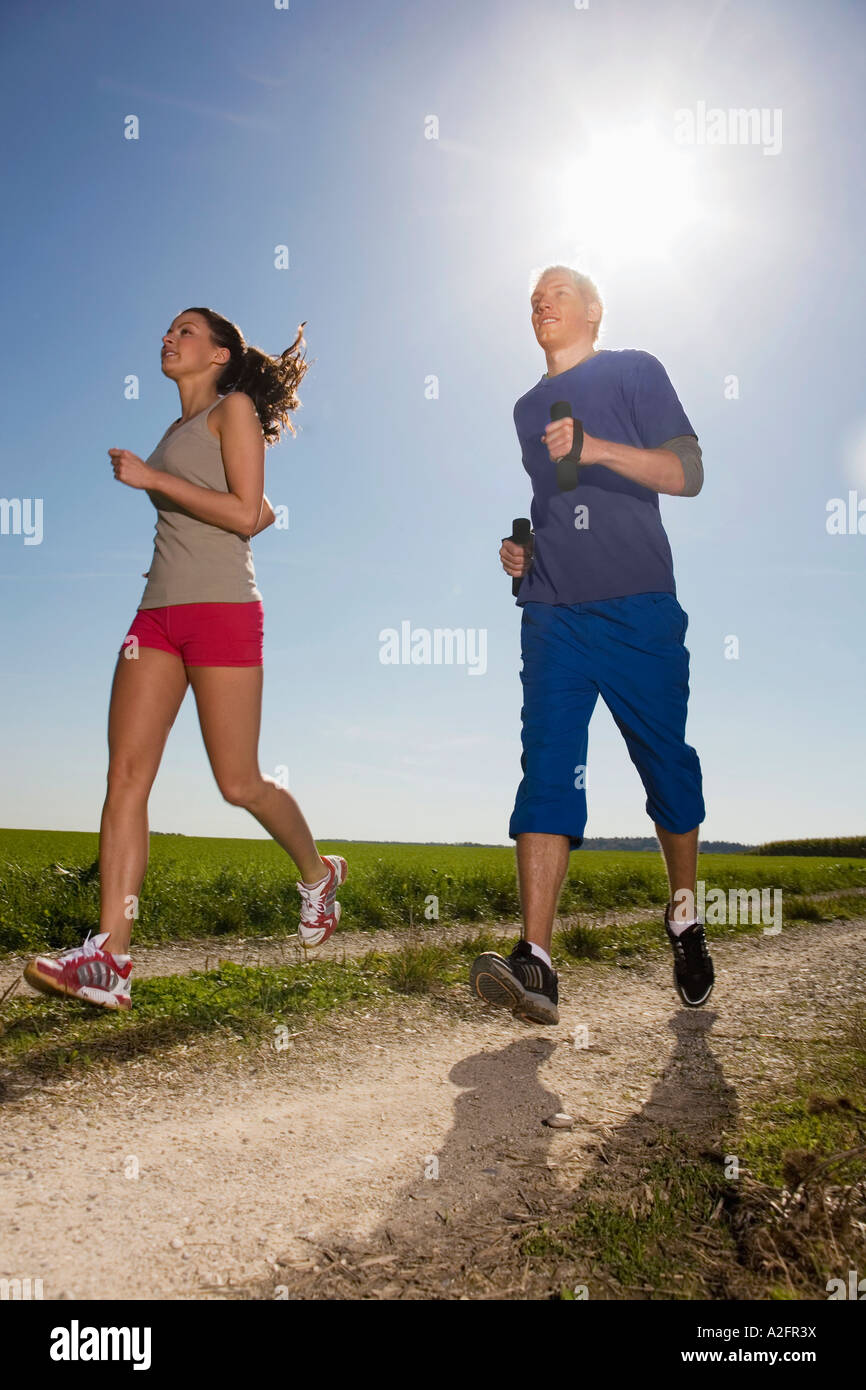 Young couple jogging, man carrying dumbbells Stock Photo - Alamy
