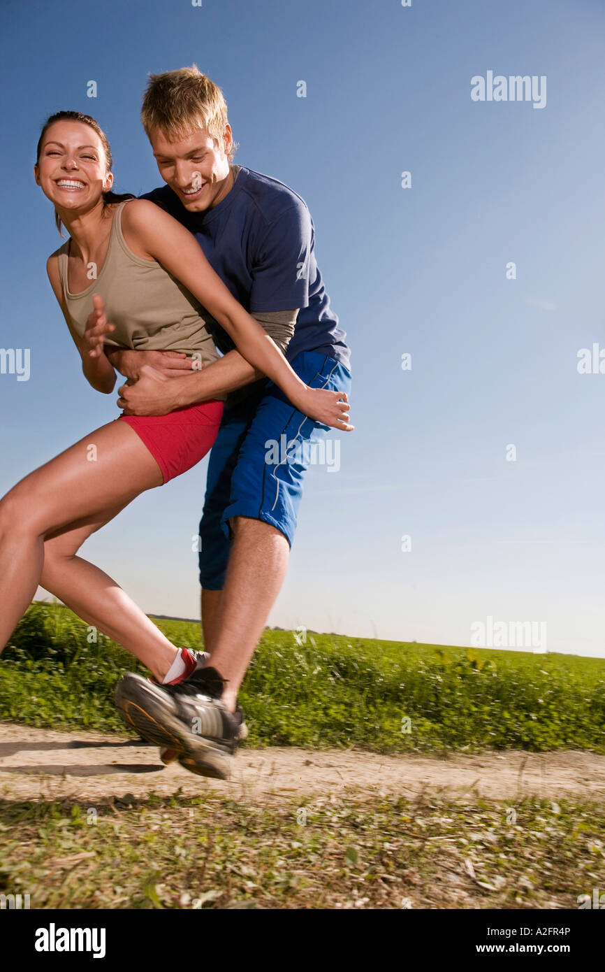 Young couple jogging, man catching woman Stock Photo - Alamy