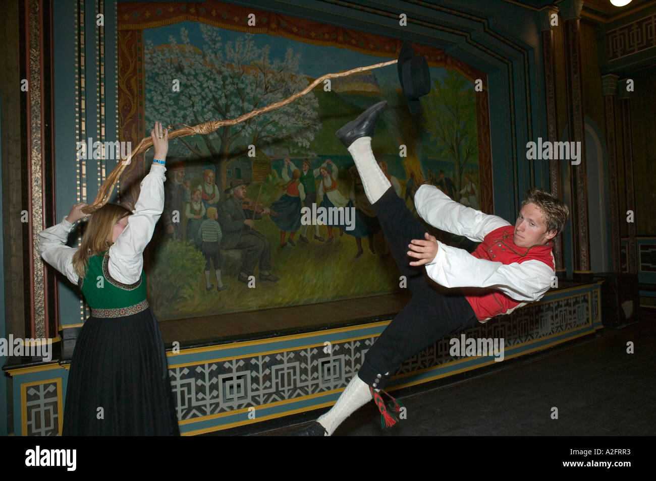 Dancer twirls trying to kick the hat from the stick, costumes designed ...