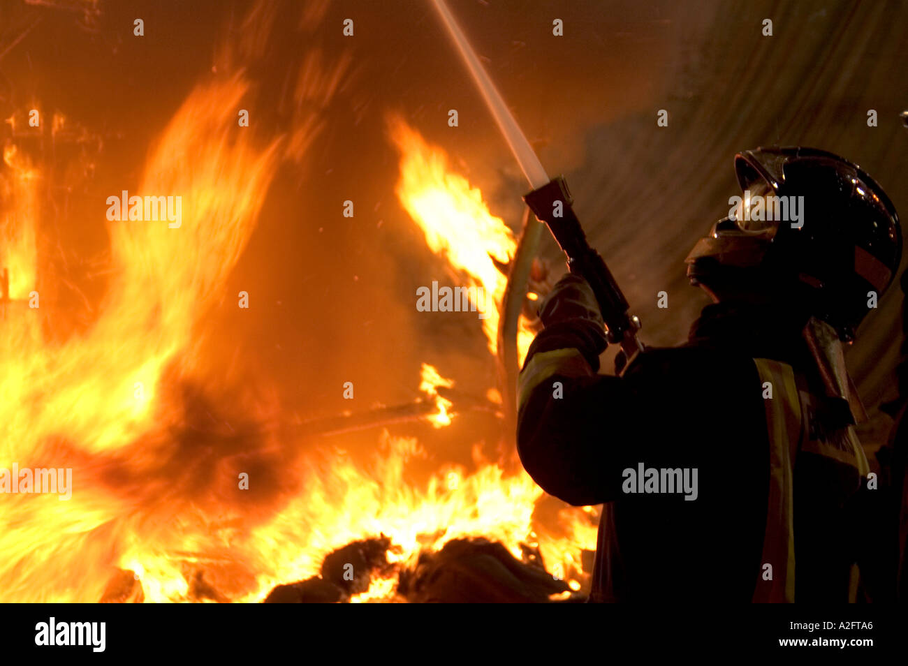 FIREMAN CONTROLS THE FIRE OF A BURNING SCULPTURE DURING LAS FALLAS IN ...