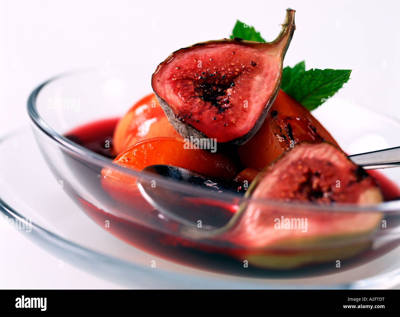 A bowl of figs in syrup on a white background Stock Photo - Alamy