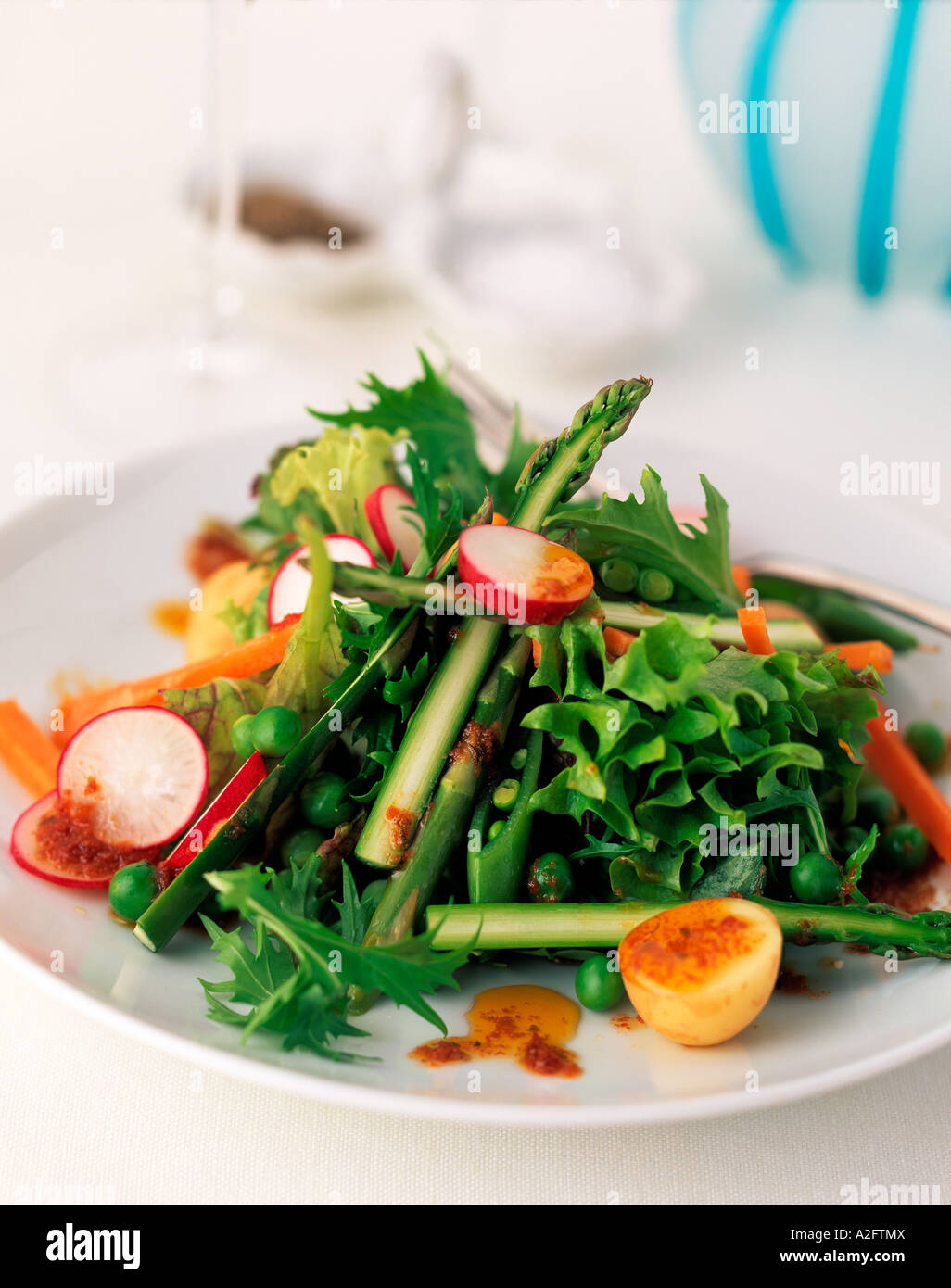A plate of spring salad in a white table setting Stock Photo - Alamy