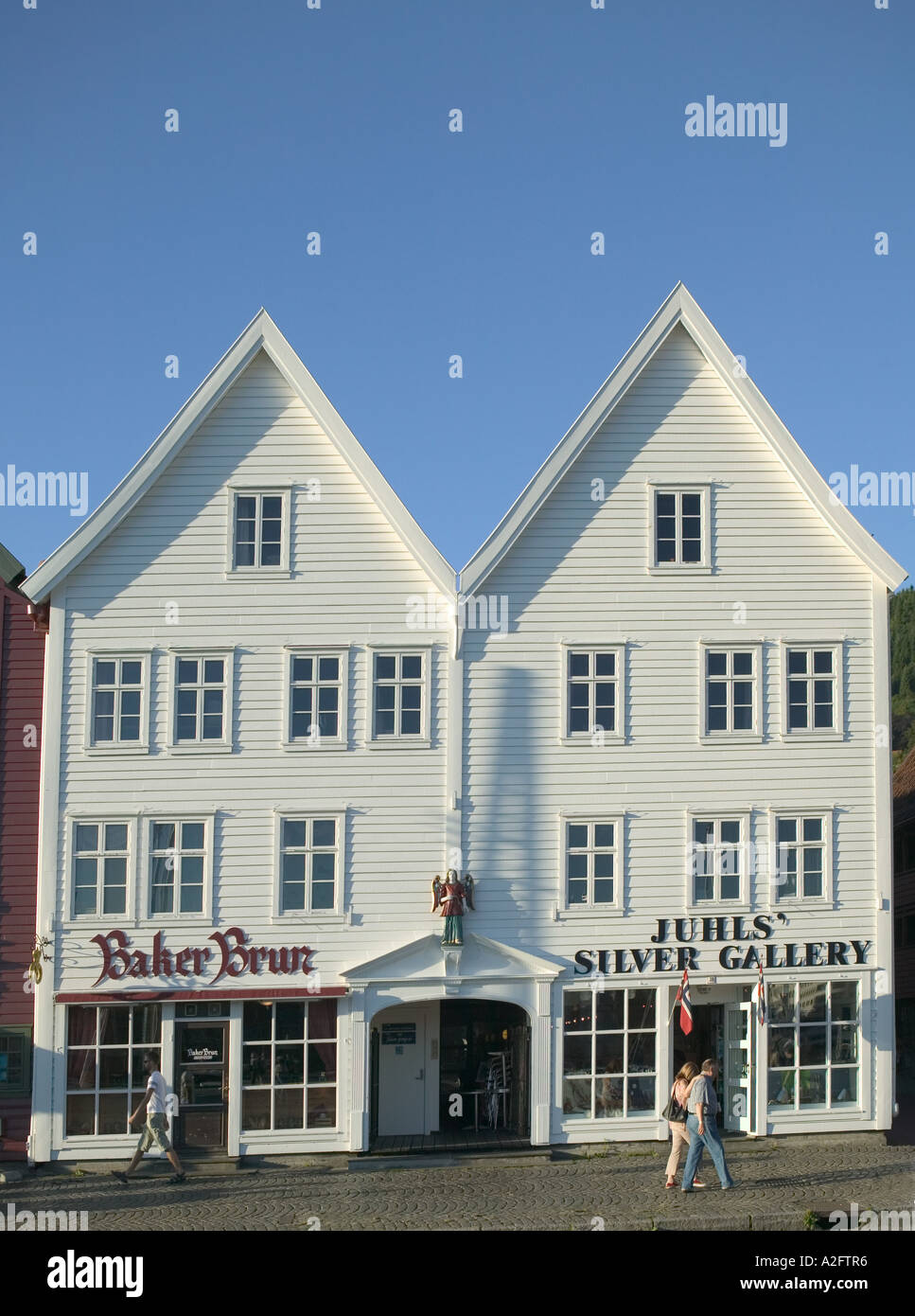 Shoppers stroll Bryggen, UNESCO World Heritage Site, ancient wood ...