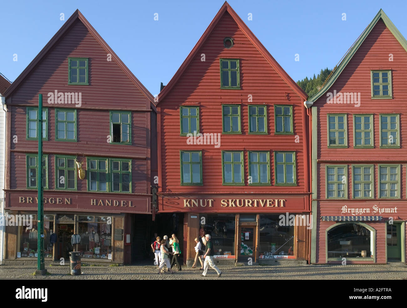 Shoppers stroll in Bryggen, UNESCO World Heritage Site, ancient wood ...