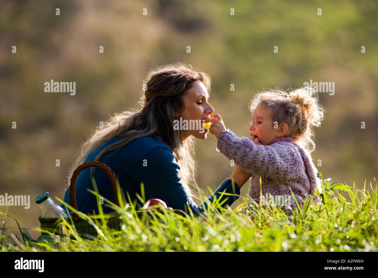 Daughter feeding mother, side view Stock Photo - Alamy