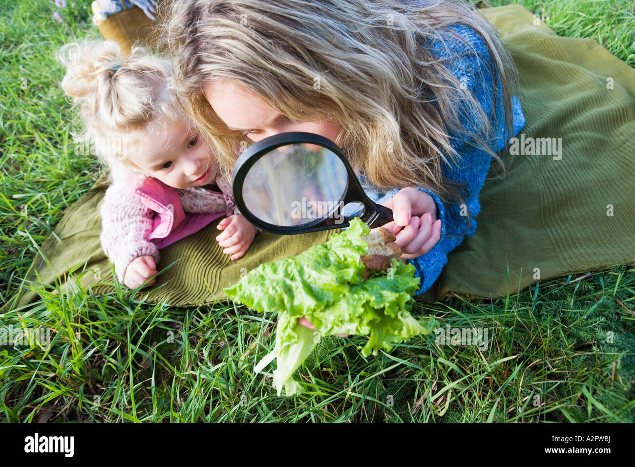 Mother and daughter watching lettuce leaf trough magnifying glass Stock ...