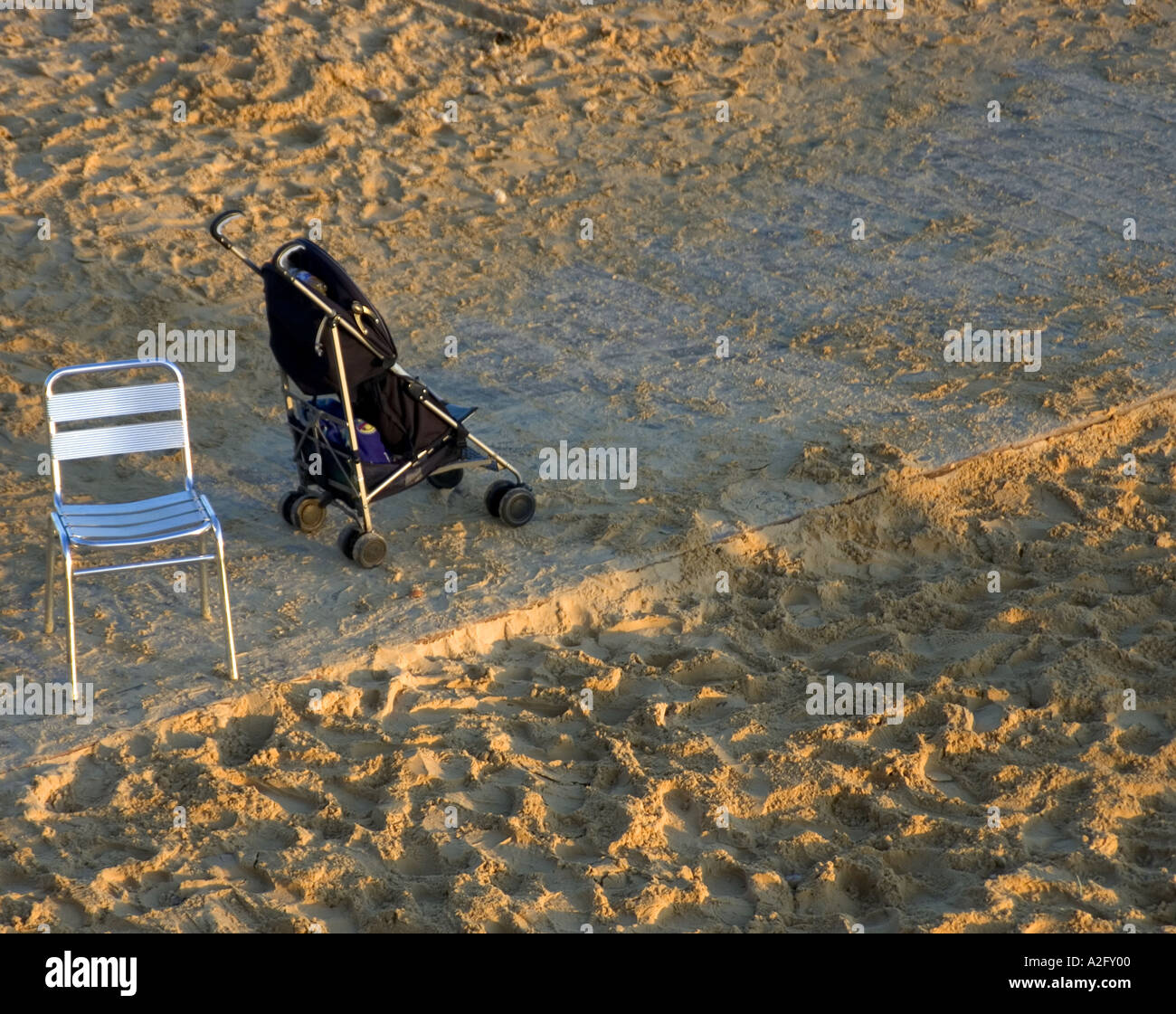 Baby buggy and steel chair on sandy beach Stock Photo - Alamy