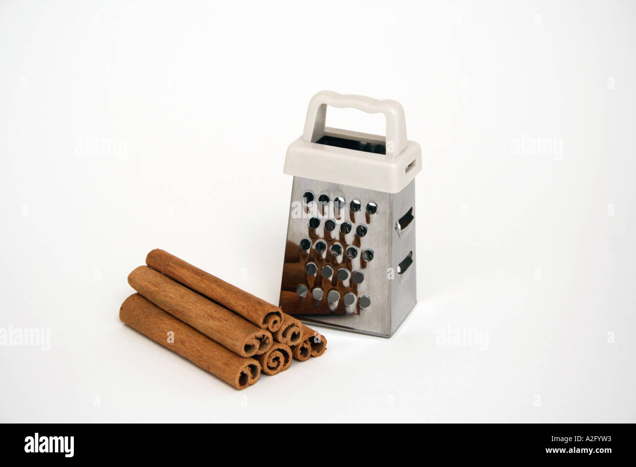 Whole cinnamon sticks with grater Stock Photo - Alamy