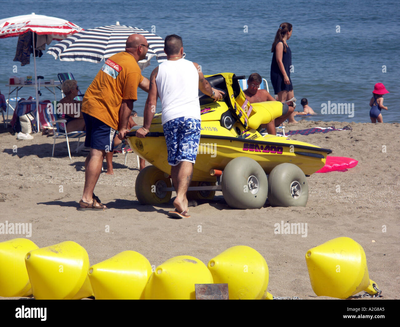 Men Pushing Jet Ski on a trolley across the beach, La Cala de Mijas ...