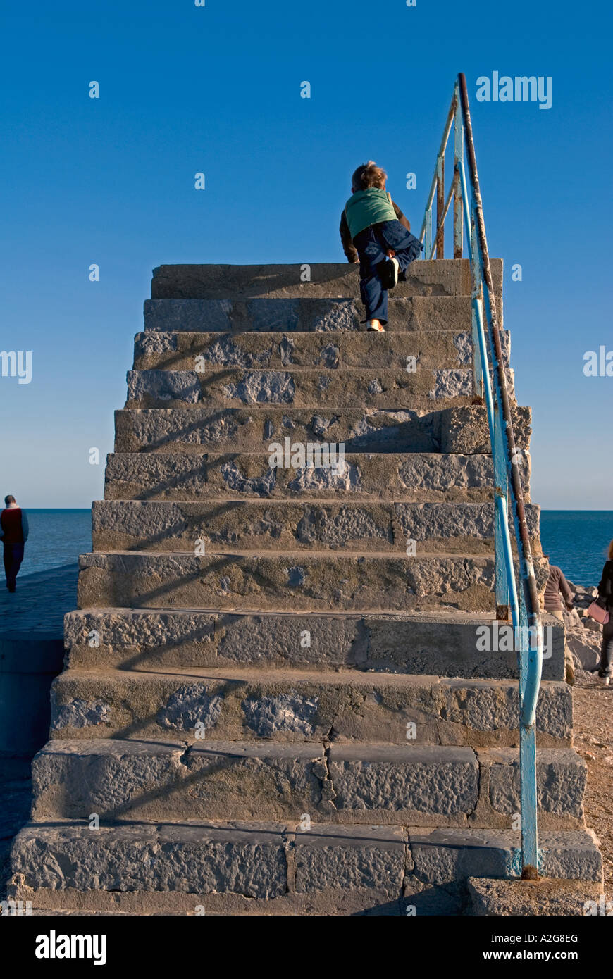a low angle photograph of small boy climbing steep stone steps Stock ...