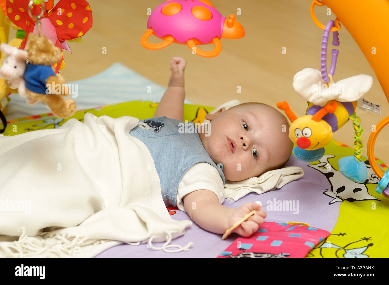 Baby Boy lying on play mat Stock Photo - Alamy