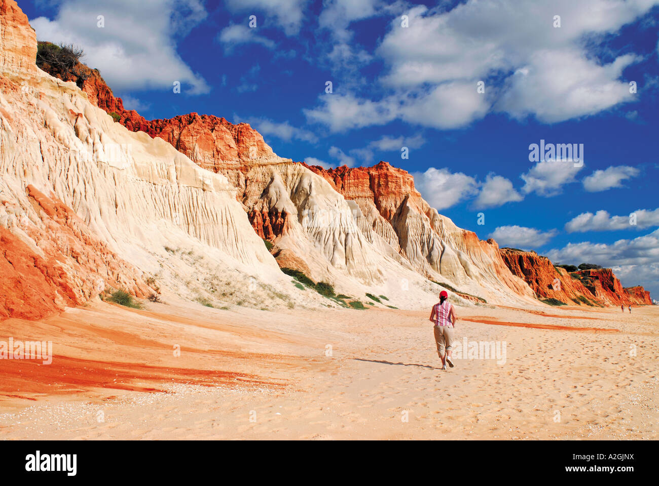 Woman running along beach Praia da Falesia, Albufeira, Algarve ...