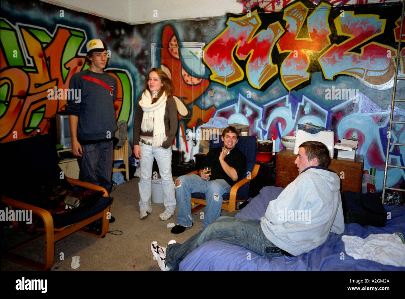 Group of friends getting together in grafitti bedroom Stock Photo - Alamy
