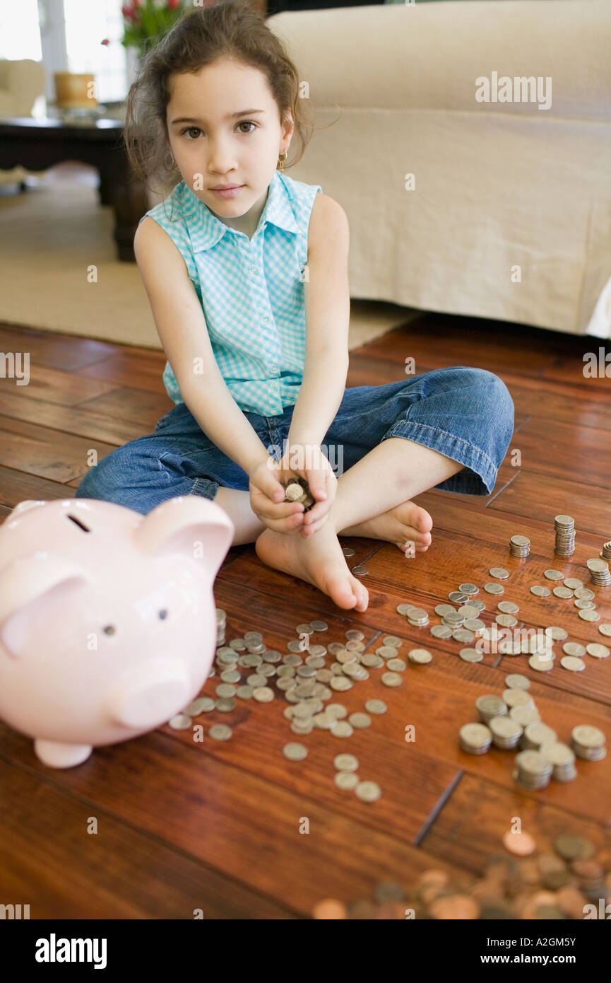 Young girl counting money next to piggy bank Stock Photo - Alamy