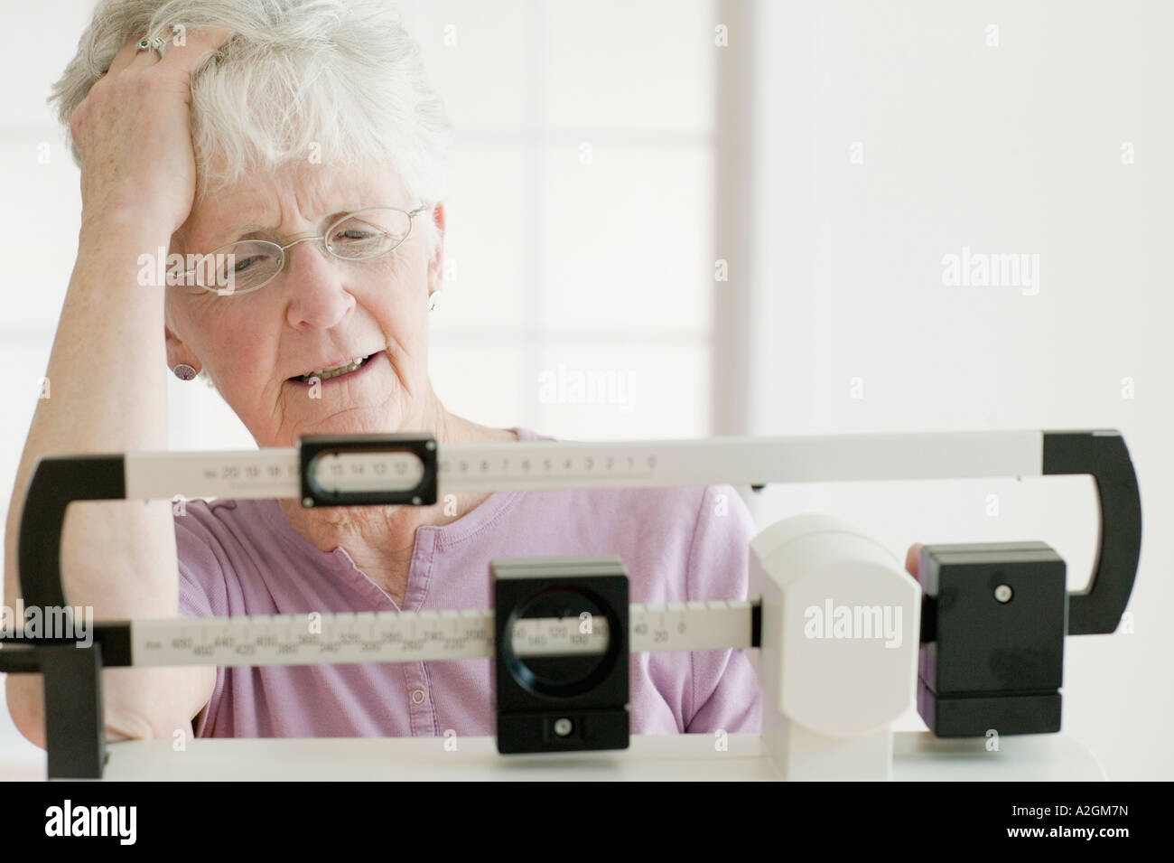 Senior woman weighing self on scale Stock Photo - Alamy