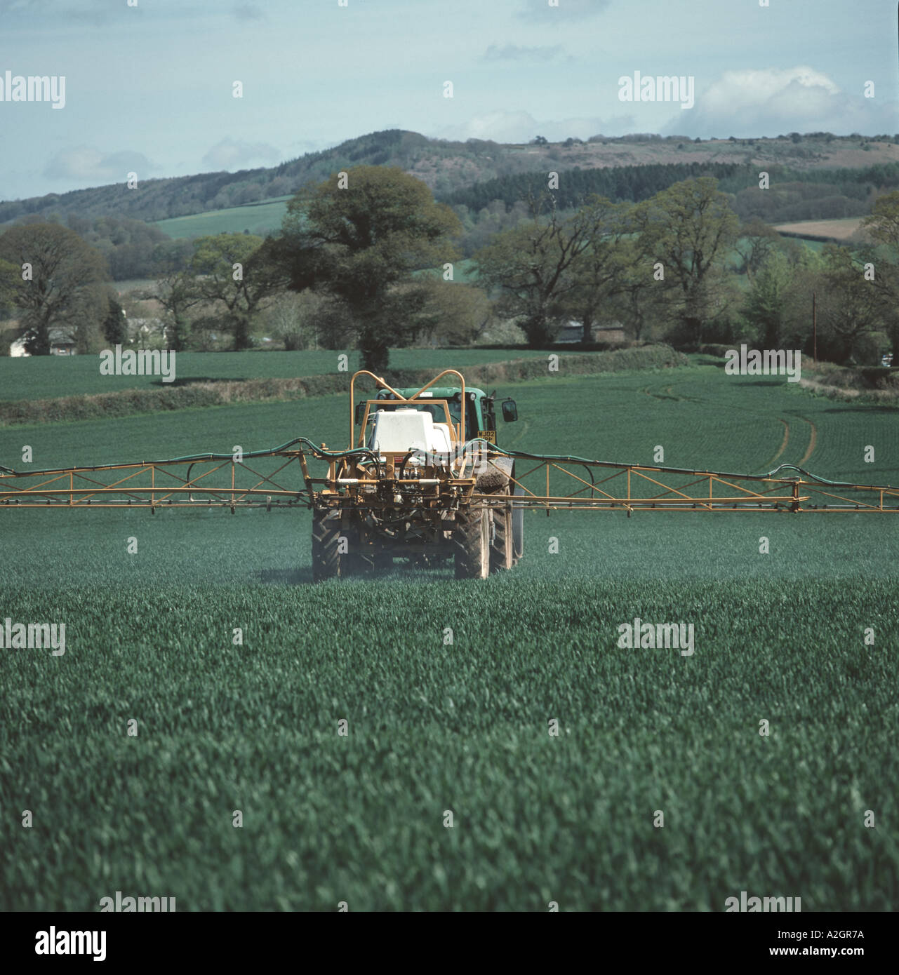 A John Deere tractor with a Knight trailed sprayer spraying a wheat ...