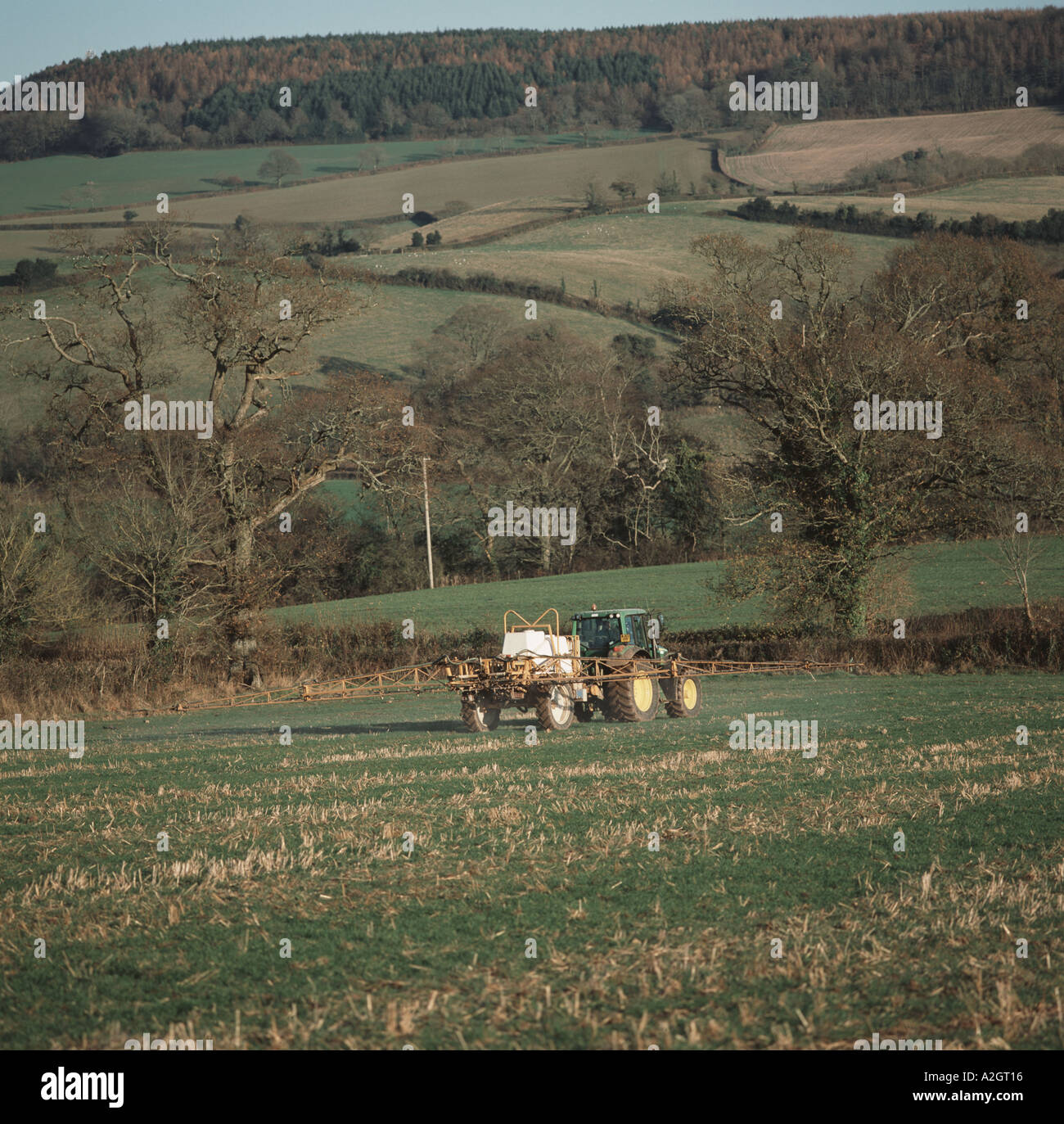 A John Deere tractor with a trailed Knight sprayer spraying a seedling ...