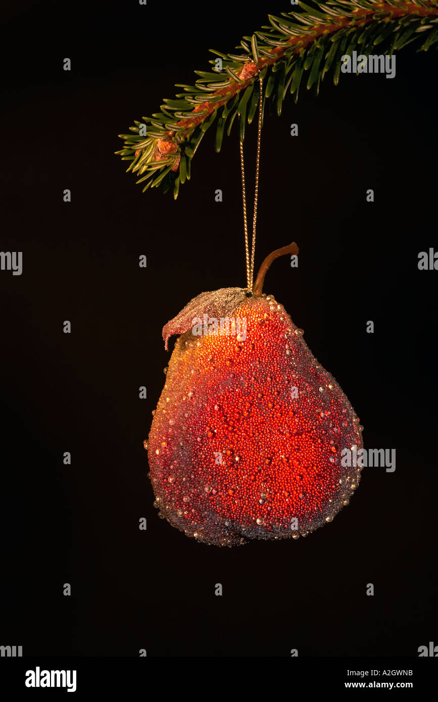 Sparkly pear fruit Christmas decoration against a black background ...