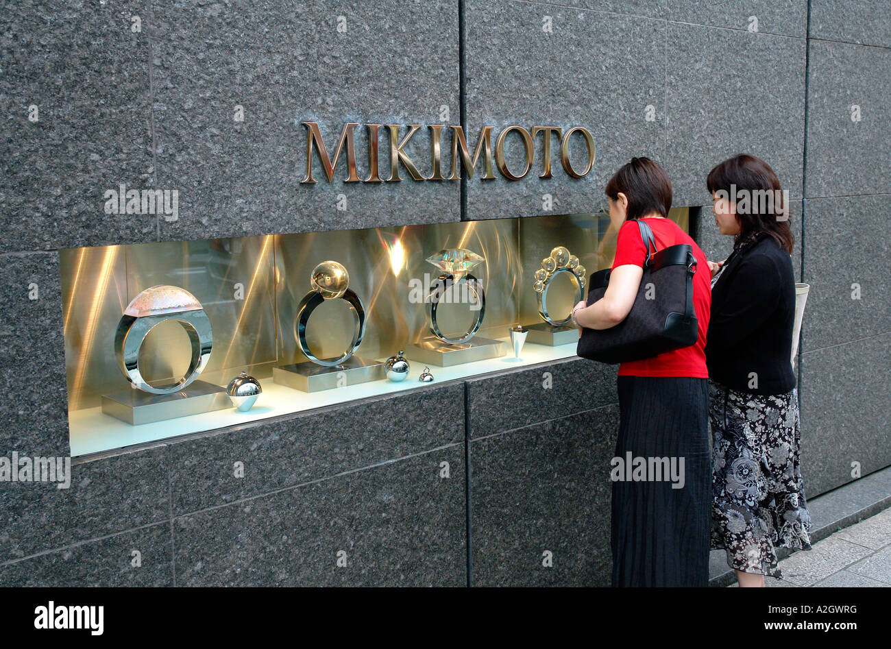Tokyo women window shoppers inspect rings, Mikimoto shop window, Ginza ...