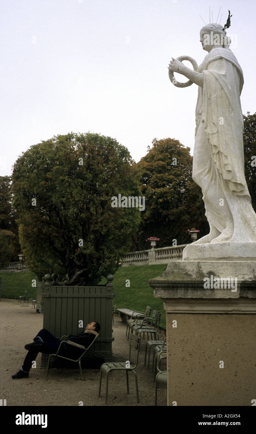 man sleeping under classical statue jardins de luxembourg paris france ...