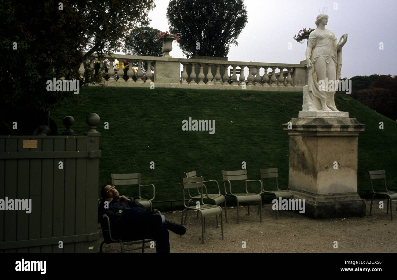 man sleeping under classical statue jardins de luxembourg paris france ...