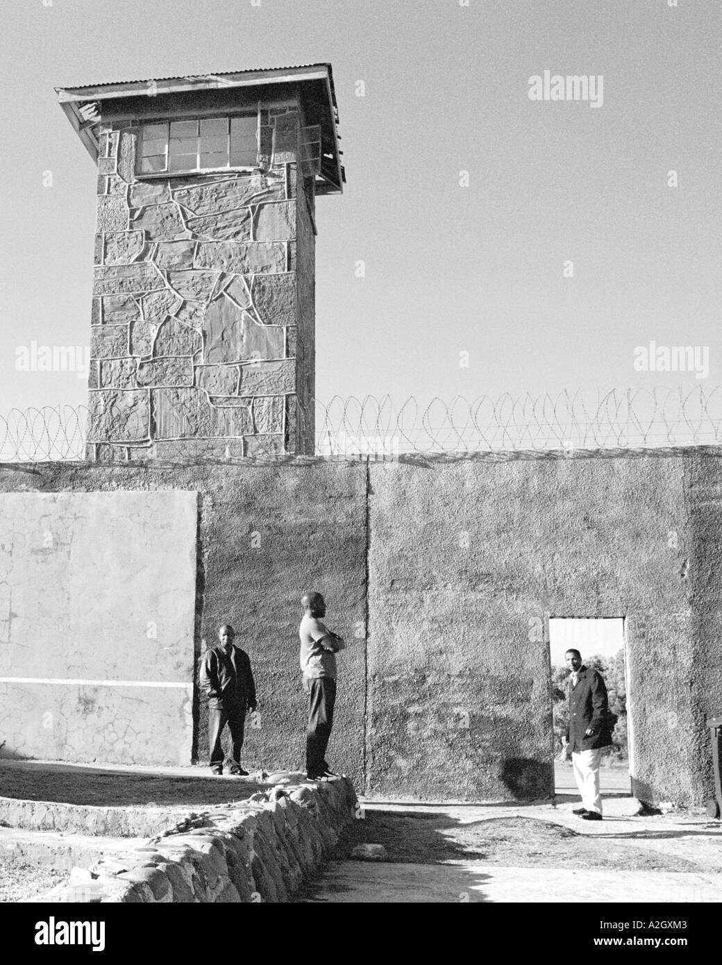 Men standing in exercise yard with watch tower Stock Photo - Alamy