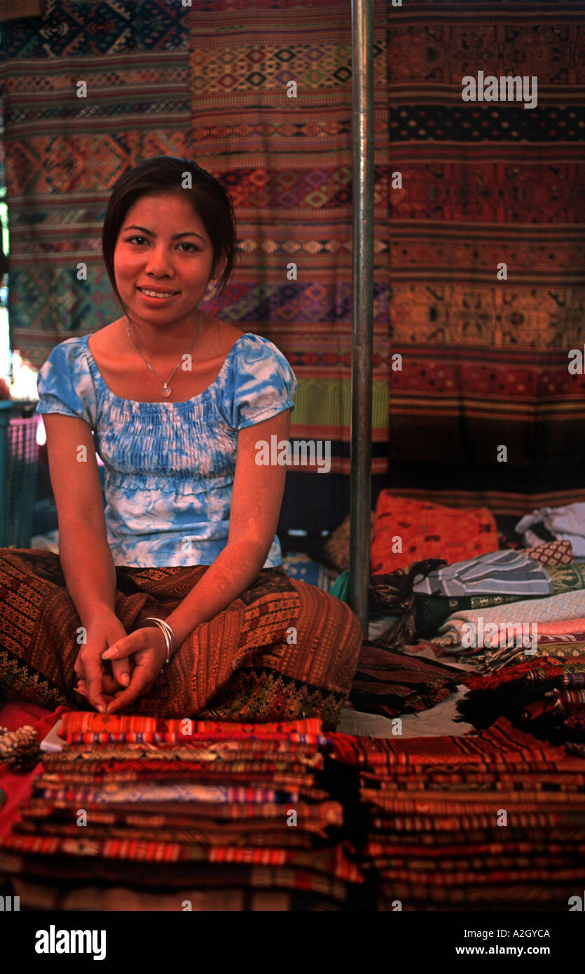 Lao textile vendor seated at her stall among footloom woven fabrics in ...