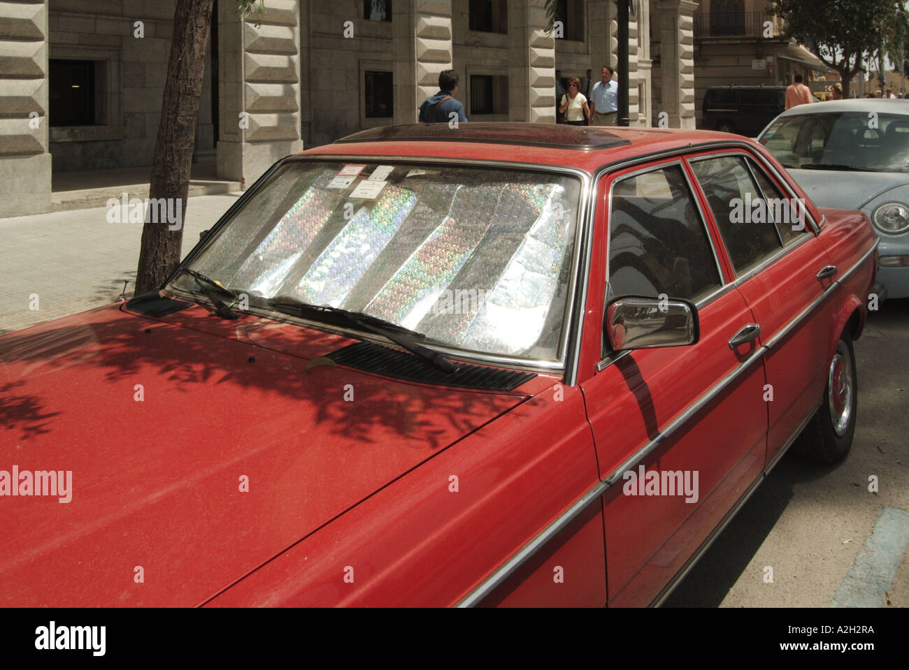 Silver foil material as sun reflector inside windscreen of red car ...