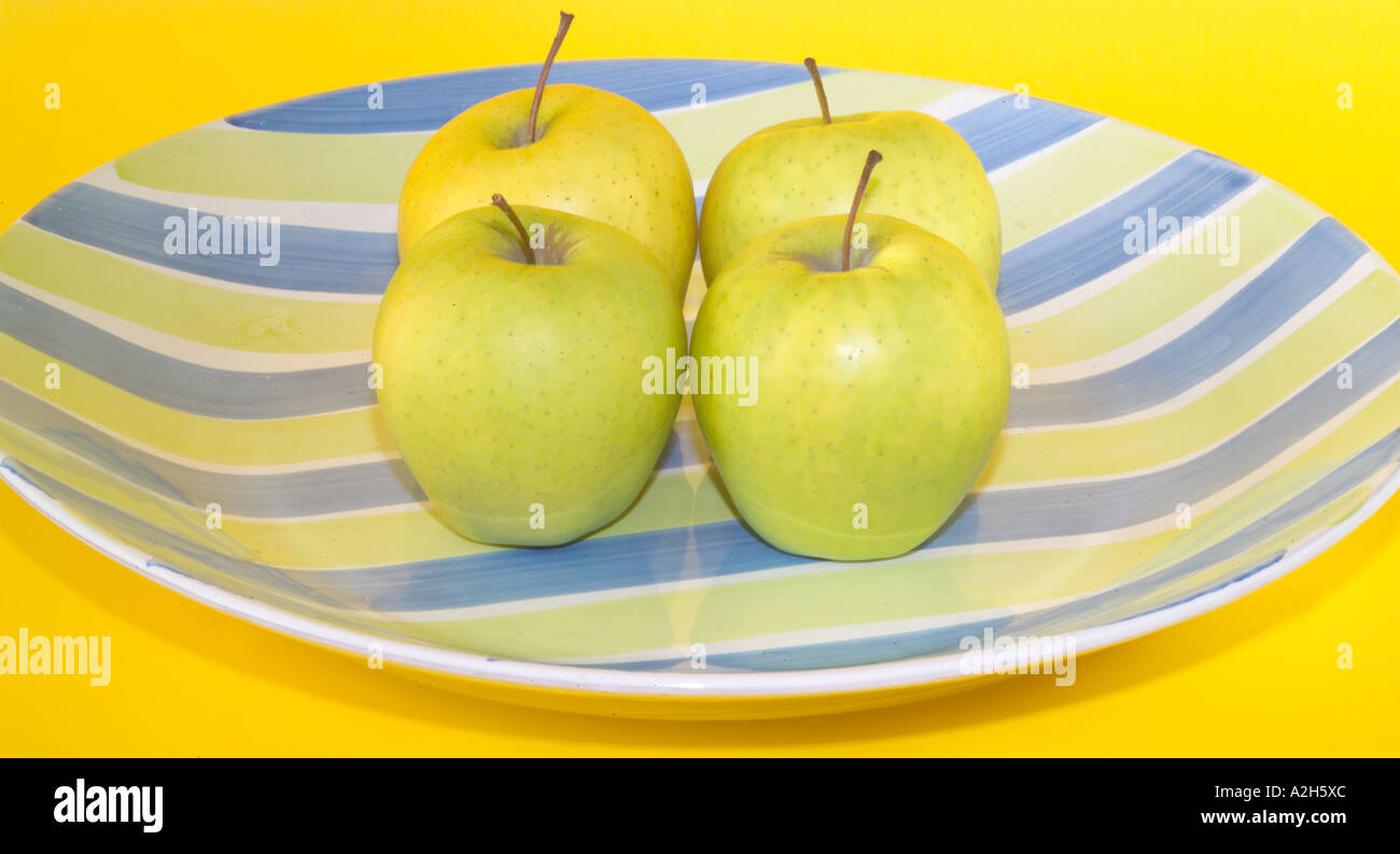 Four yellow apples on the striped plate Golden delicious Stock Photo ...