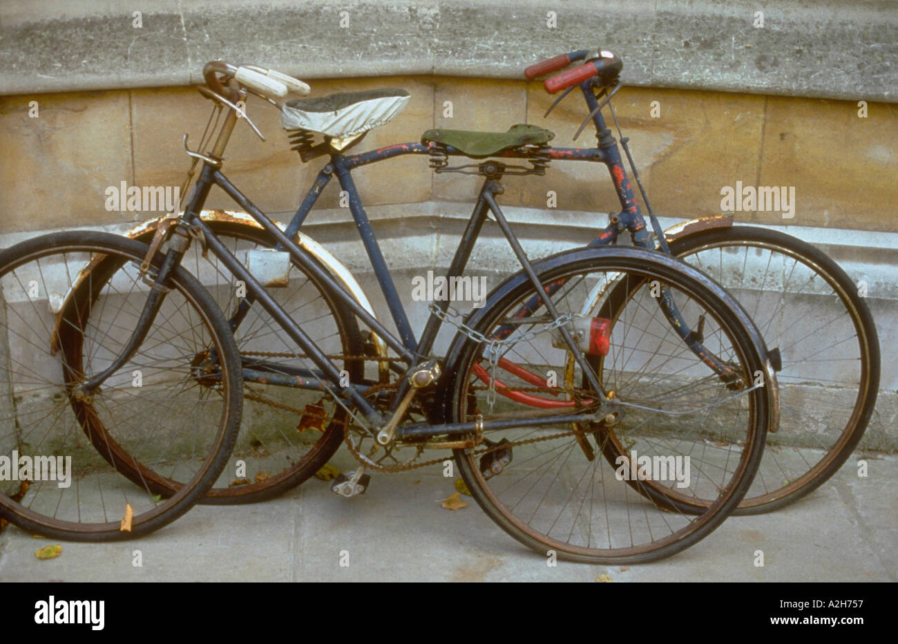 Two old English bicycles resting together against brick wall Stock ...