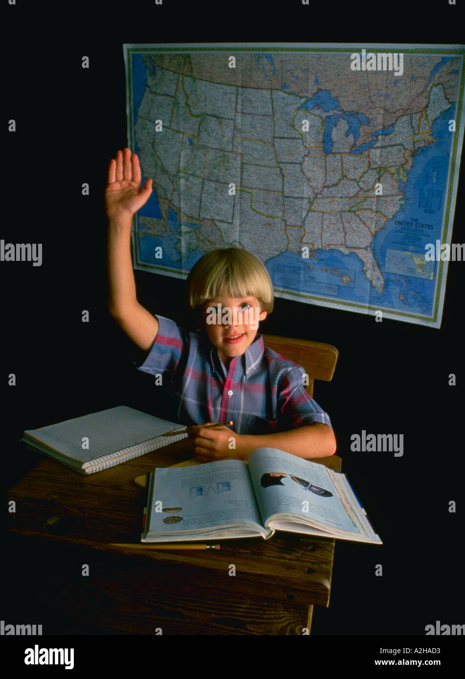 Young boy raising his hand in school Stock Photo - Alamy