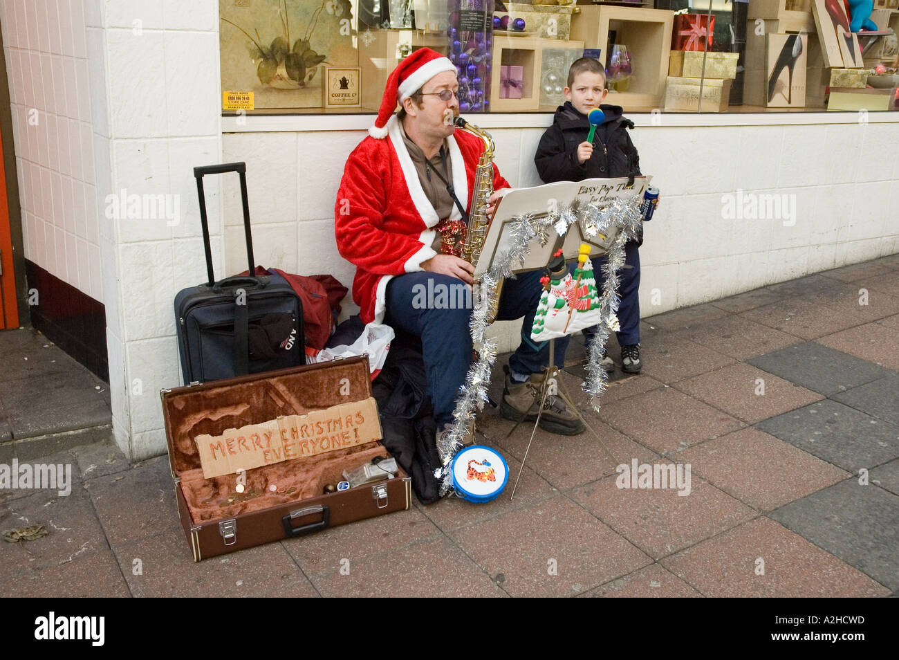 Busker wearing a Santa Claus outfit playing a saxophone Stock Photo - Alamy