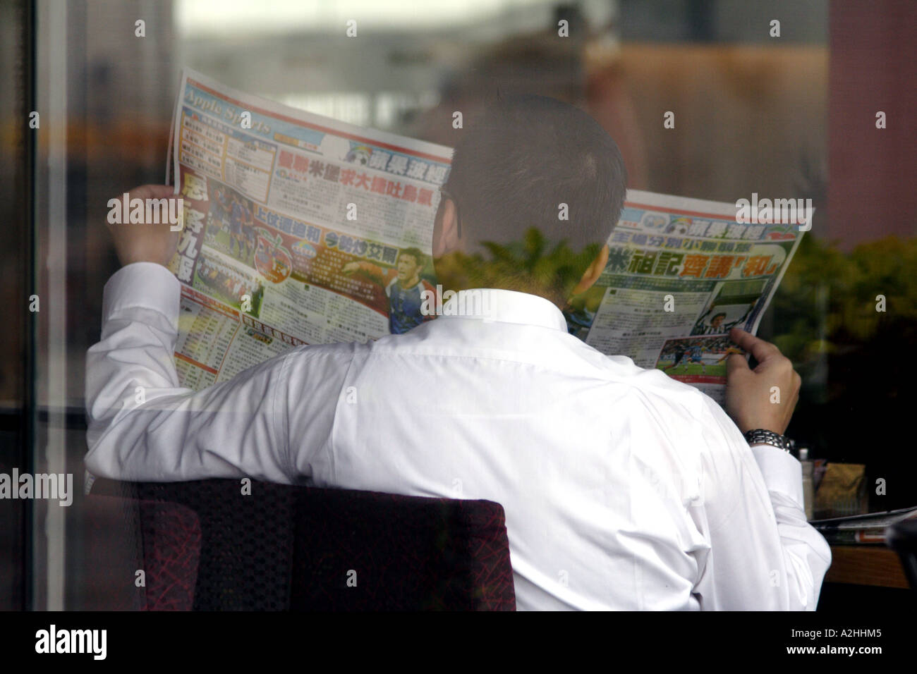 Businessman reading a newspaper behind a window in a Coffee Shop, Hong ...