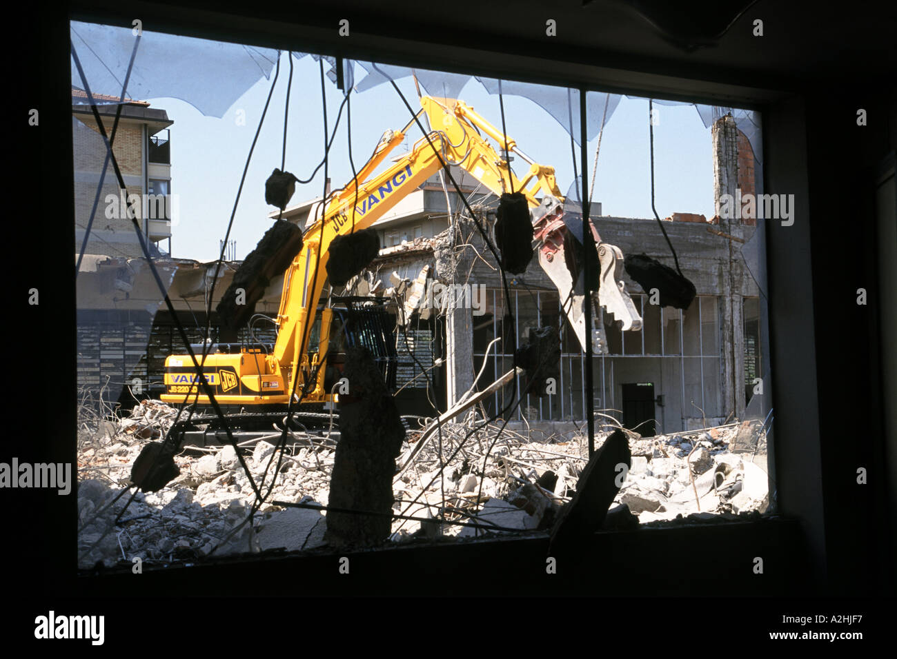 A JCB digger works on demolishing a building in Italy Stock Photo - Alamy