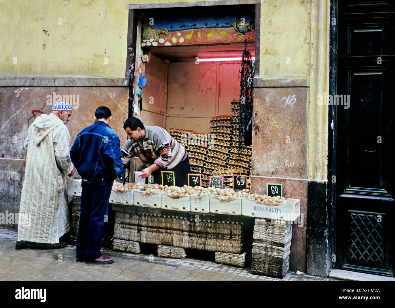 AFRICA MOROCCO TANGIER Moroccan men in traditional dress buying eggs ...