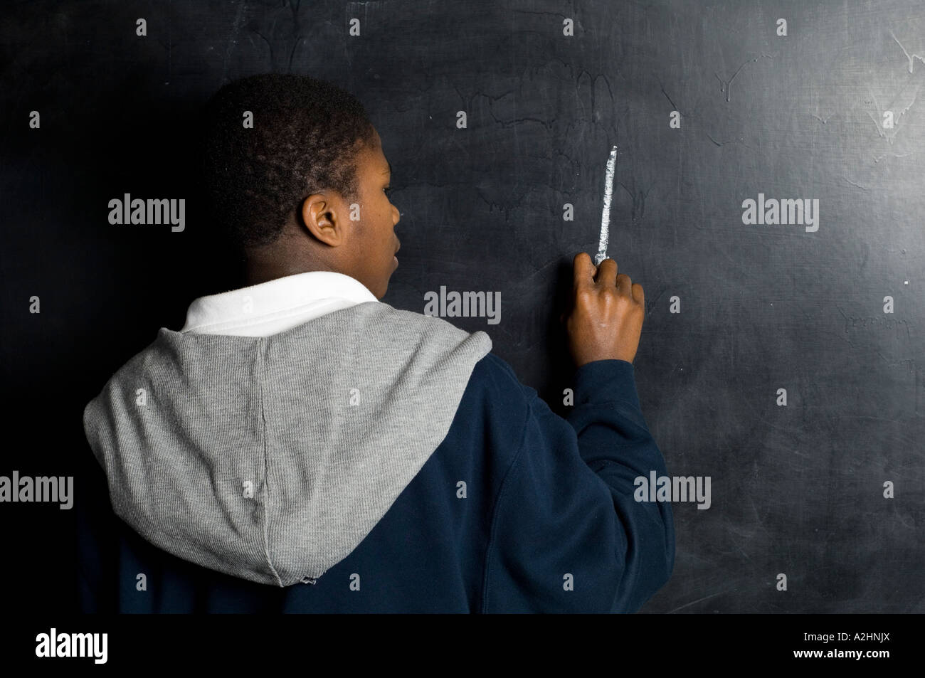Student writing on blackboard Stock Photo - Alamy