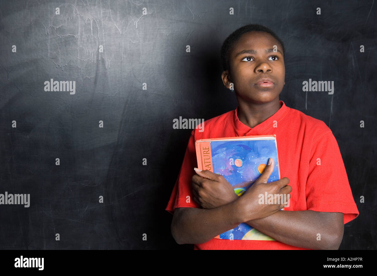 Student in Classroom Holding a Book and Looking UP Stock Photo - Alamy
