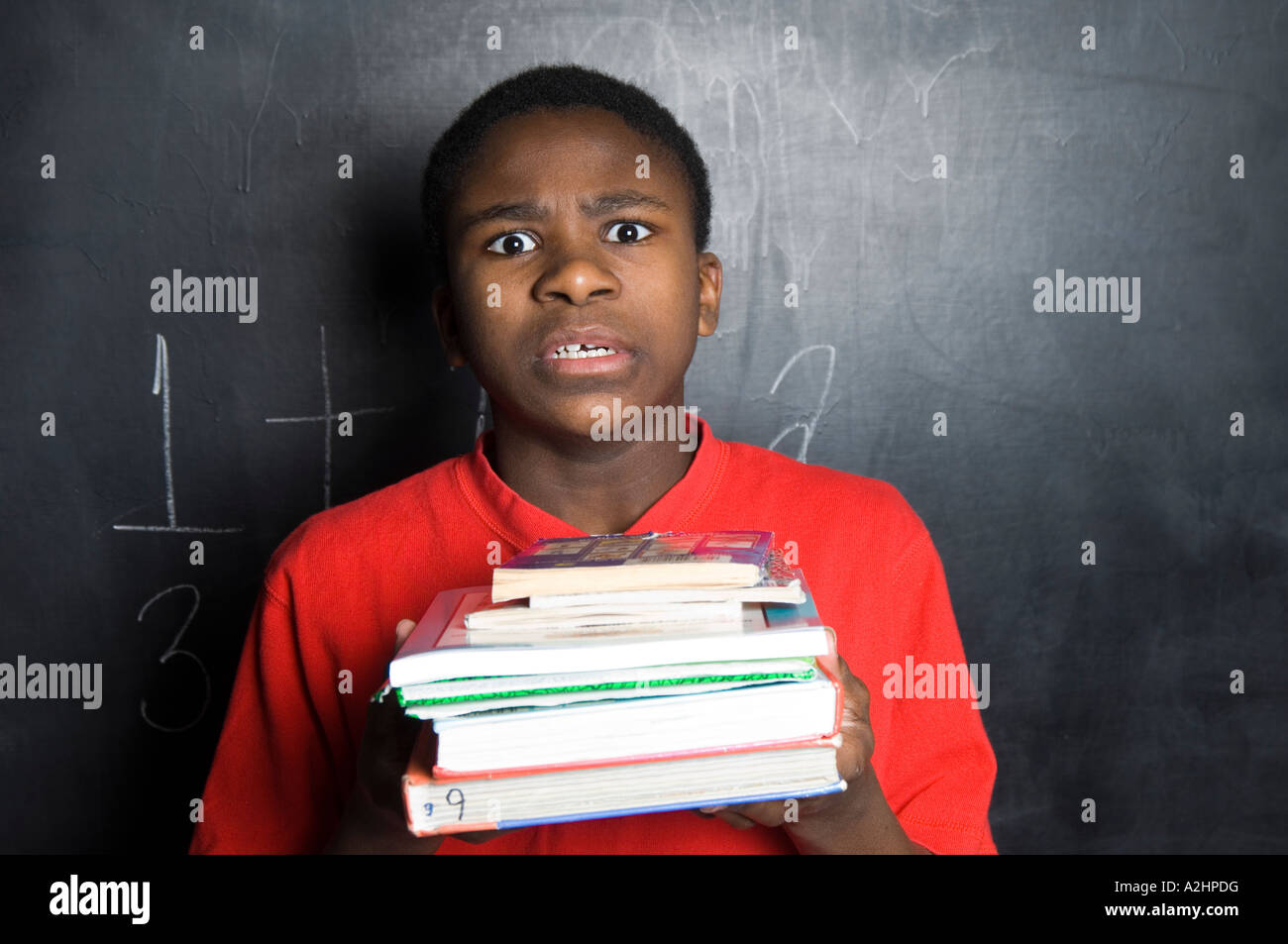 Student with books in classroom Stock Photo - Alamy