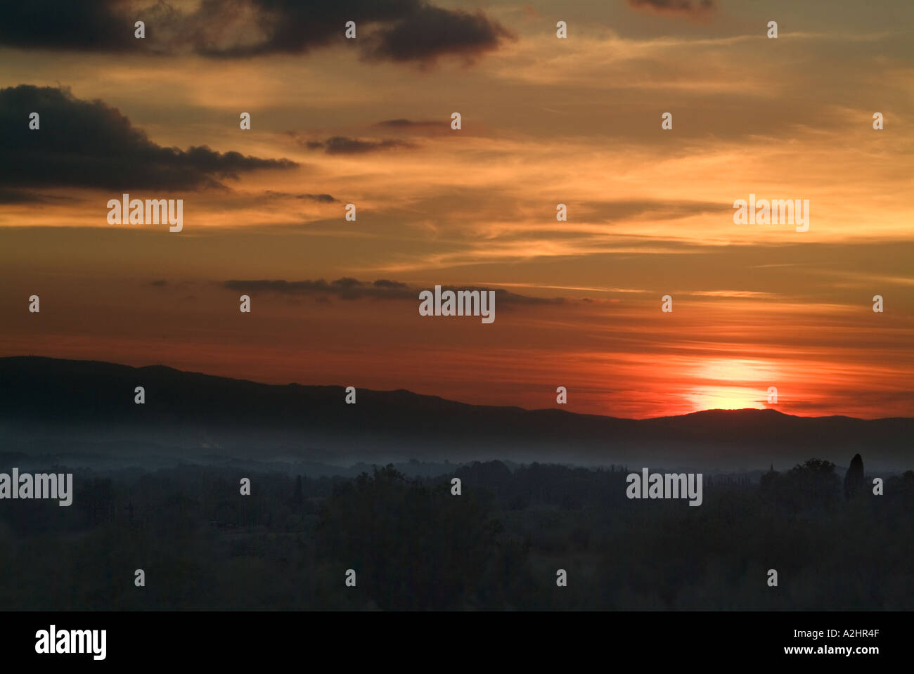 Sunset over mountain range with mist in the valley below Stock Photo ...