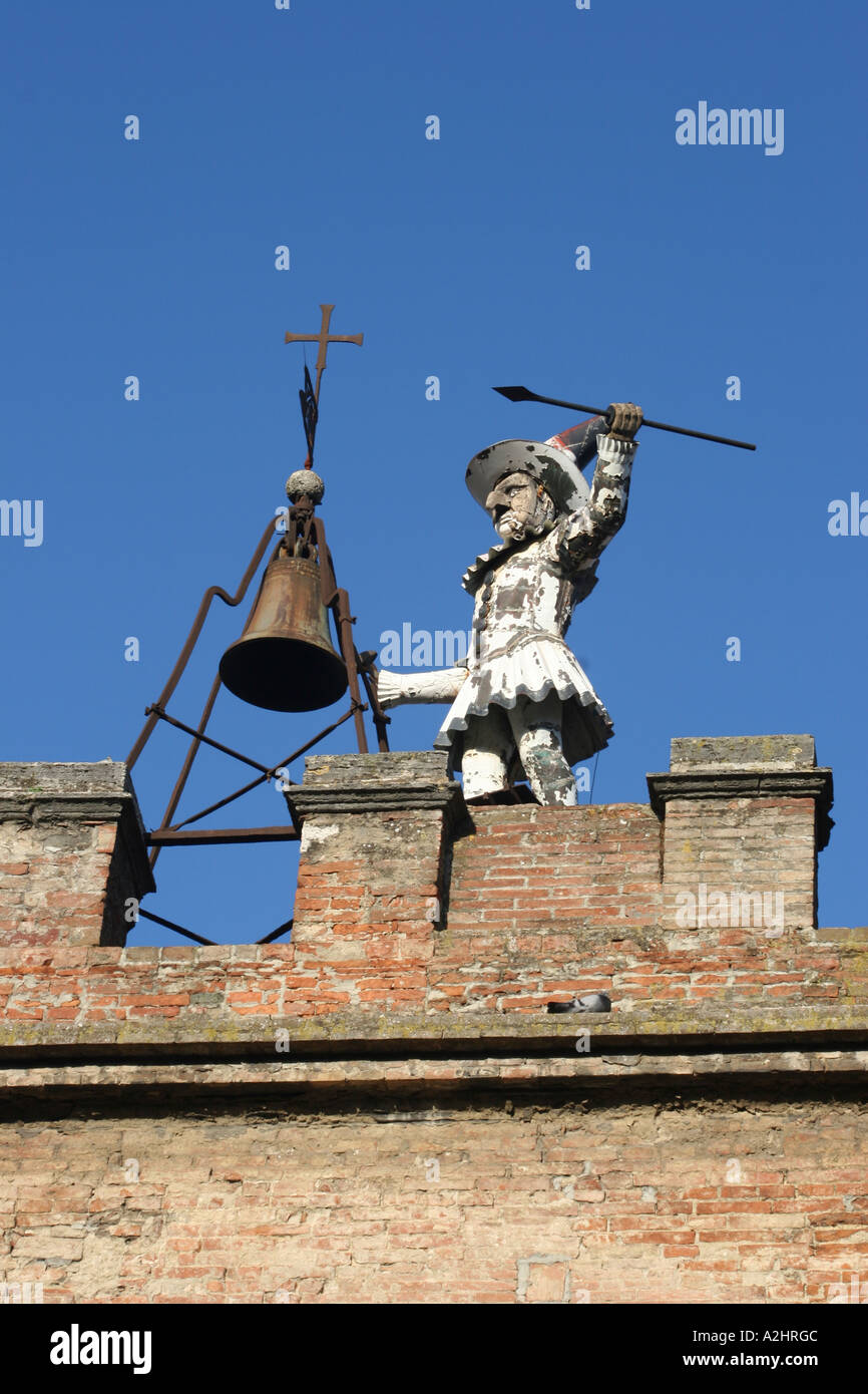 Copper figure aiming spear at a bell on a rooftop in Montepulciano ...