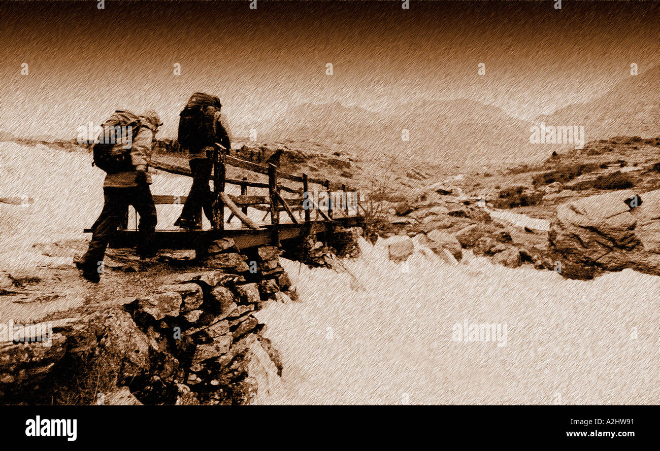 2 people wearing mountaineering equipment walking across a bridge in ...