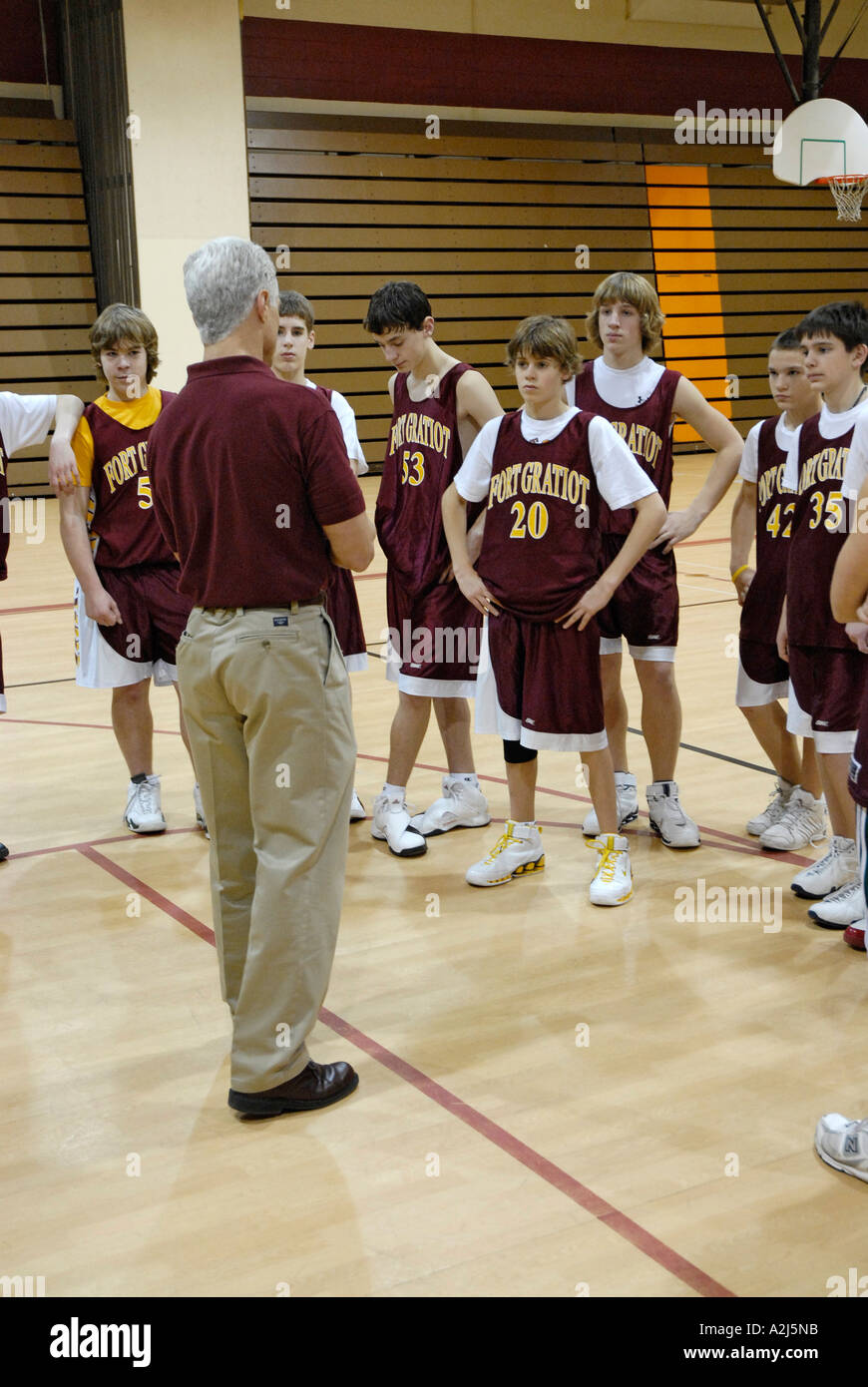 Coach of middle school grade 8 basketball team talks with member of ...